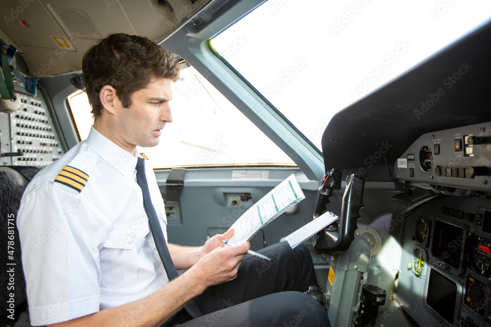 Male pilot checking control panel in airplane cockpit Stock Photo ...