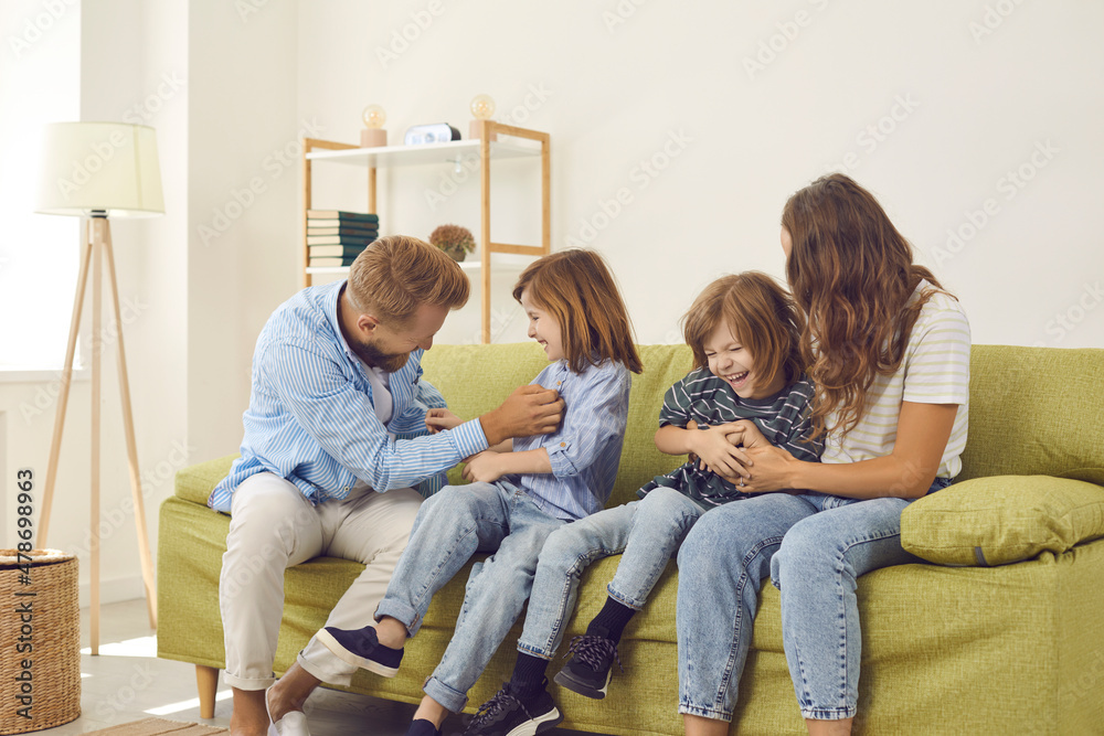 Happy family having fun on sofa at home. Cheerful young European ...