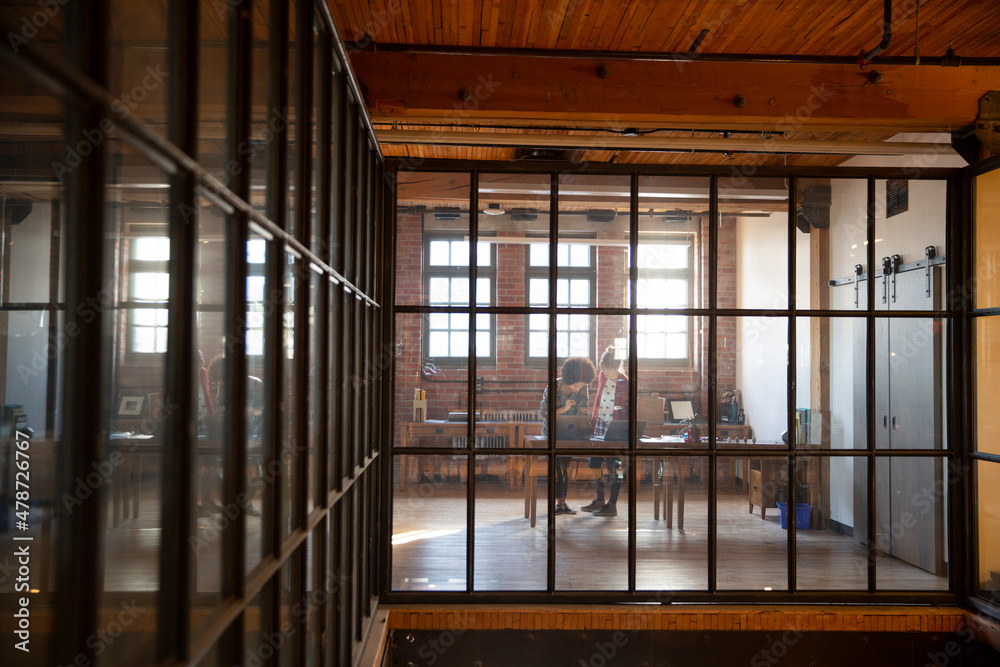 Designers working in industrial office in distance Stock Photo | Adobe ...