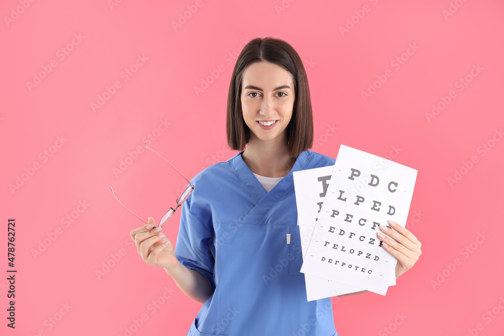 Female nurse with glasses and vision test on pink background Stock ...