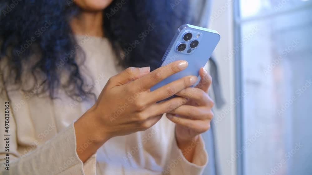 Young adult african woman using modern mobile phone at home on lockdown ...