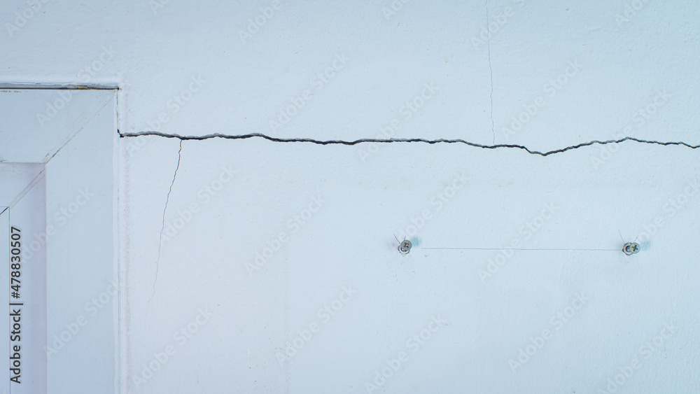 Cracks on the wall. The crack in the cement wall at the window sill ...
