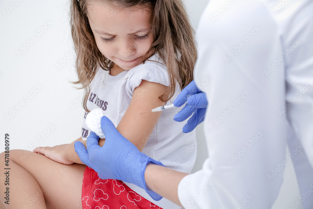 Criança tomando vacina no braço com prevenção do covid 19 e medico com ...