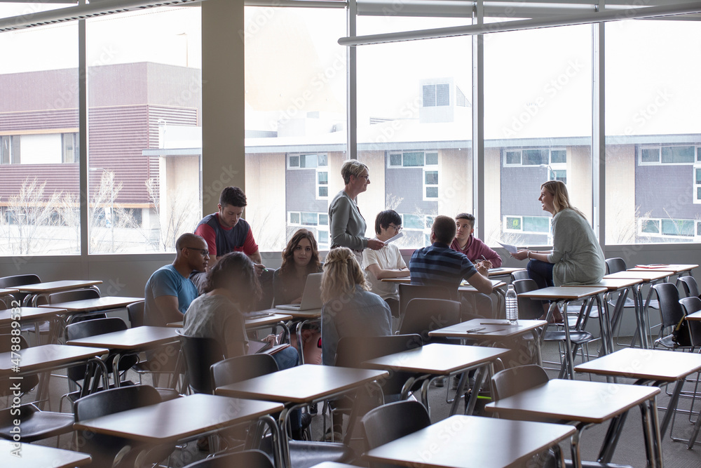 Professor and college students studying in groups classroom Stock Photo ...