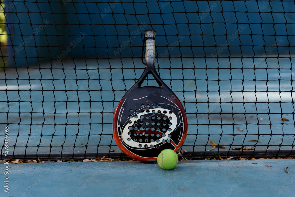 Padel racket and a ball on the court Stock Photo | Adobe Stock