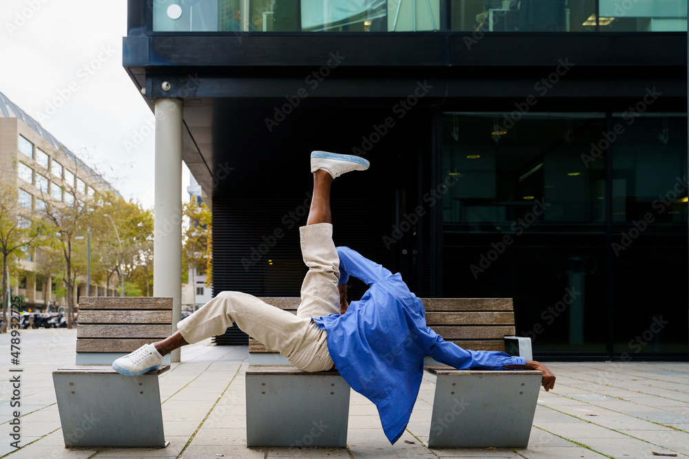 Stylish man stretching and doing pose on bench Stock Photo | Adobe Stock
