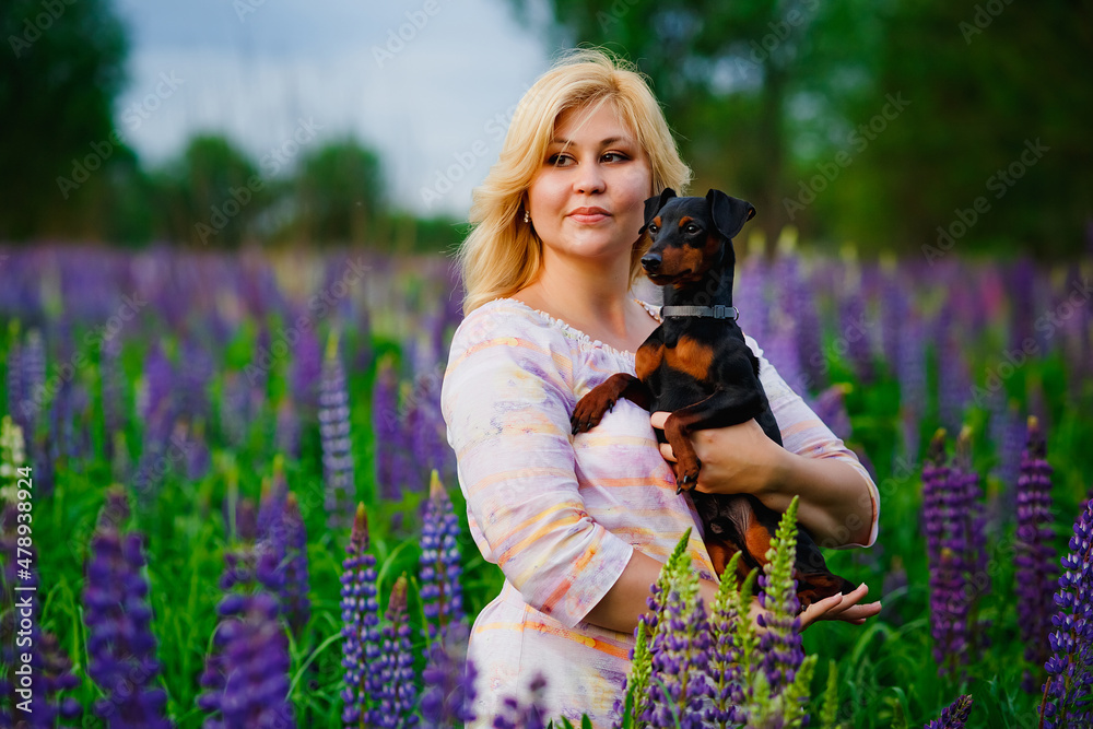 Dog and women concept - . A young plump blonde woman hugs and kisses ...