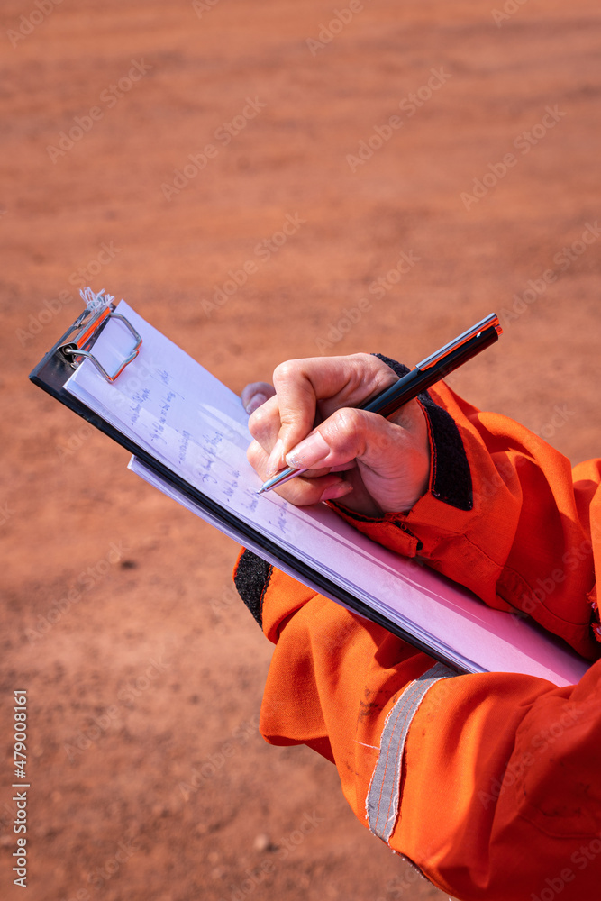 A supervisor is taking note on paper during perform inspection audit ...