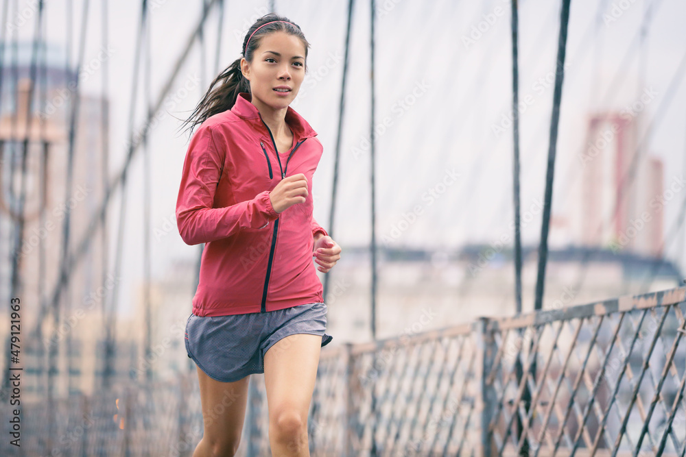 Sports athlete woman runner running on Brooklyn Bridge, New York City ...