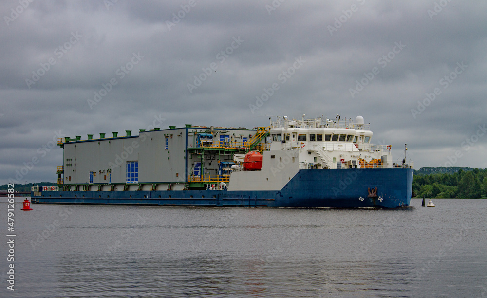 Cargo ships sail along the river. Large cargo barges carrying inland ...