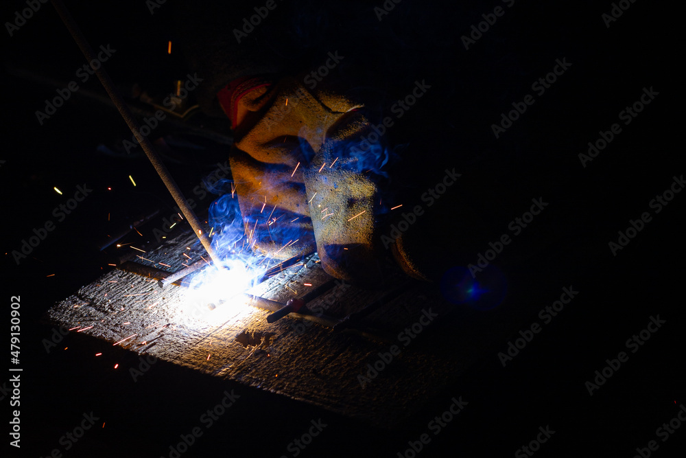 Welding metal with sparks. A man's hand in a glove with welding ...