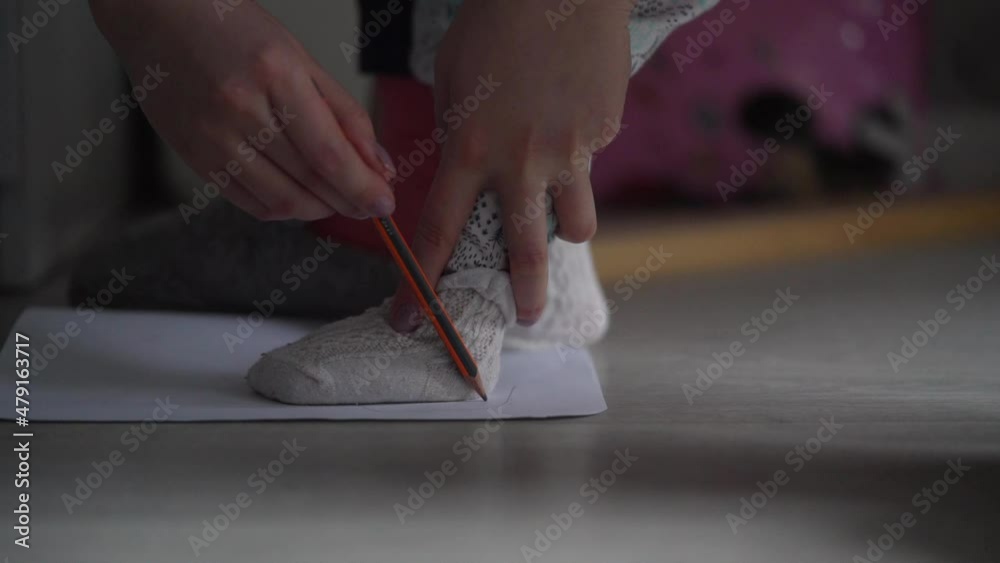 Checking baby foot size mother holding leg of her child on the blank ...