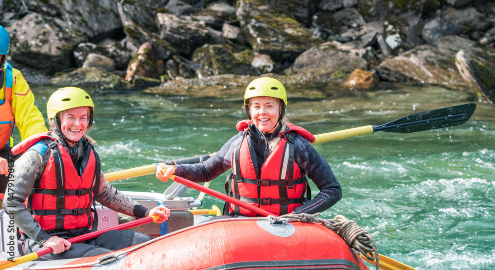 Two girls enjoying themself with river rafting water sports. Smiles ...