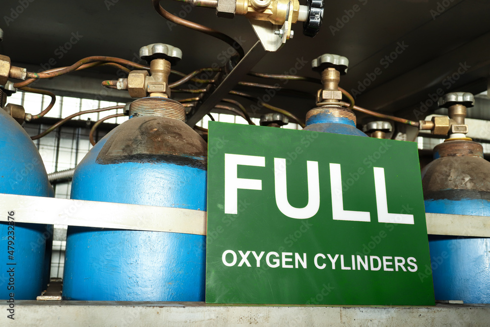 Foto de Green signboard notifying about full oxygen cylinders behind a ...