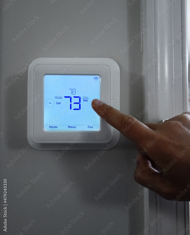 Person adjusting the home temperature on a smart thermostat Stock Photo ...