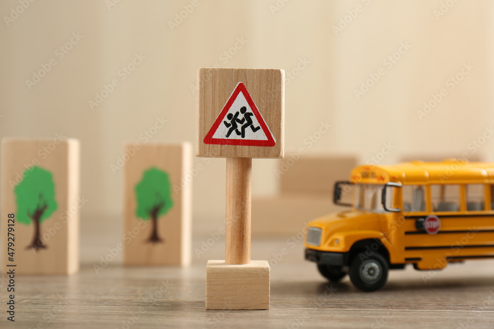 Traffic sign Attention children crossing street and toy bus on wooden ...