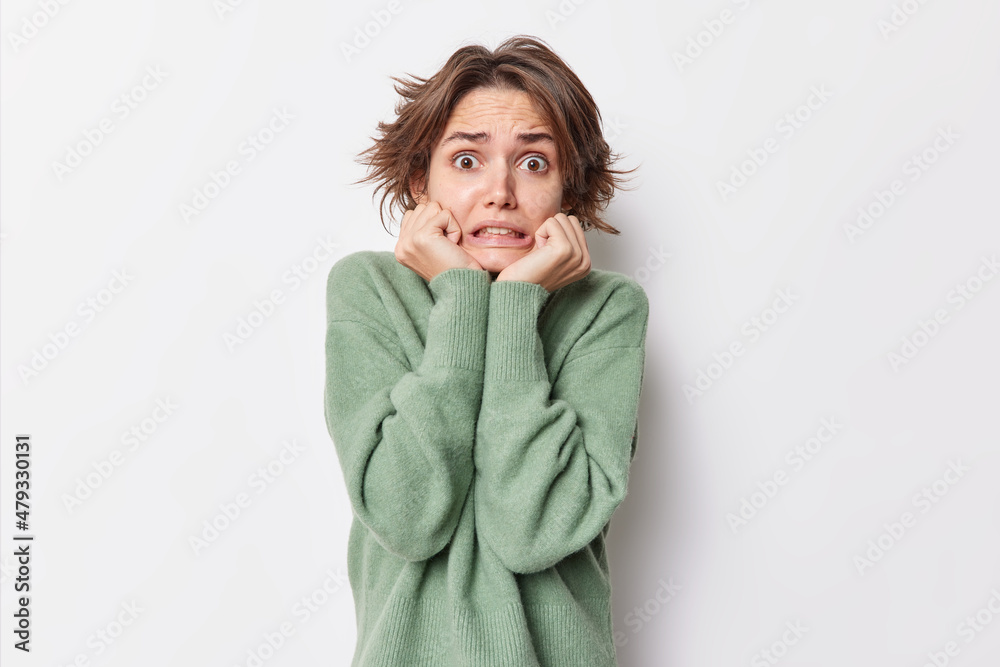 Worried stressed young woman keeps hands under chin afraids of ...