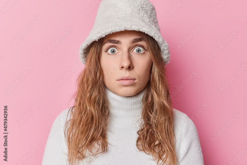 Shocked impressed woman with long hair stares bugged eyes cannot ...