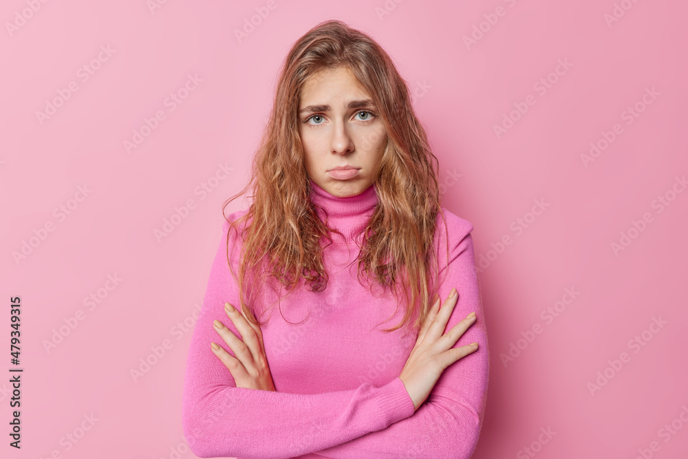 Upset offended young woman has gloomy sullen expression holds hands ...