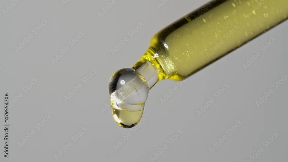 Drops of oil extract dripped from a glass pipette for chemical ...