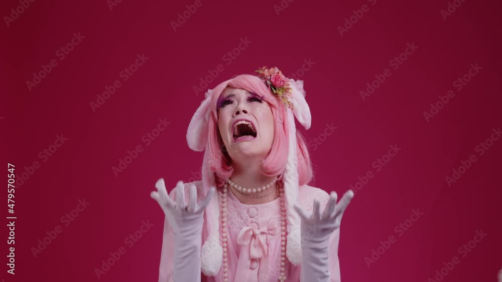 Vidéo Stock Pink sad cute candy girl with plush rabbit ears is crying ...