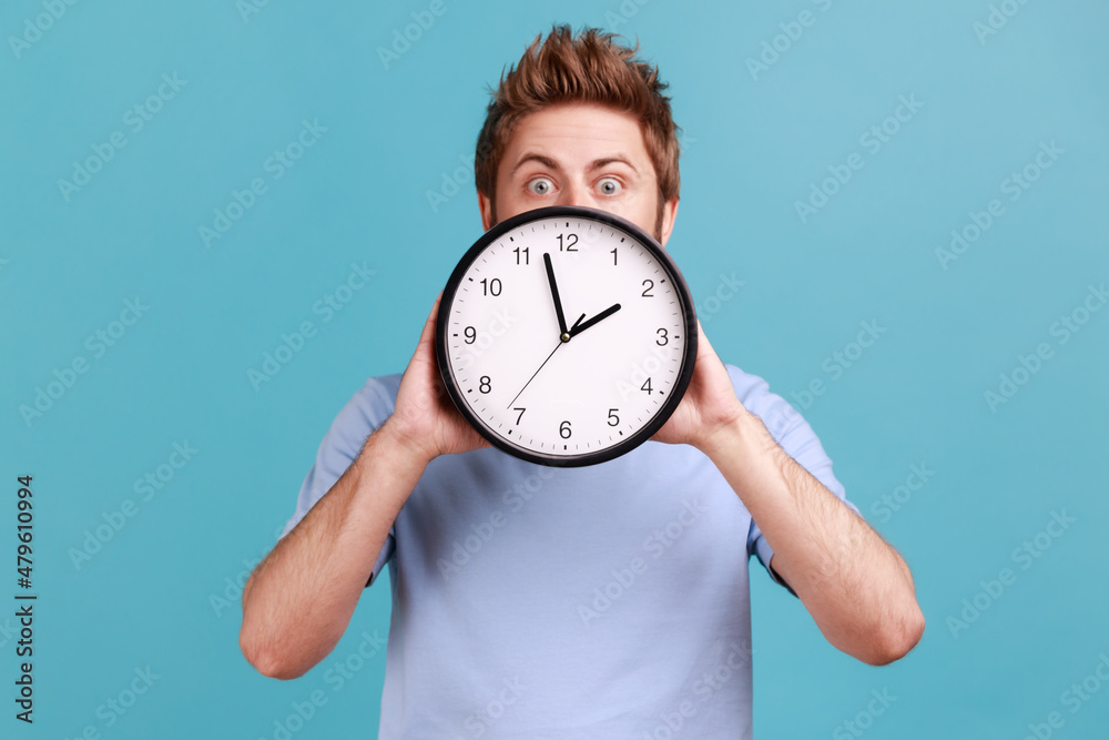 Portrait of astonished handsome young adult man covering half of face ...