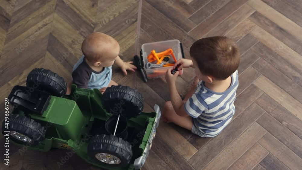 two little brothers kids playing repairing toy car as mechanic using ...