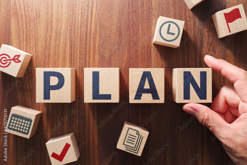 The word "plan". Issue of planning. Putting wood cubes with alphabets ...