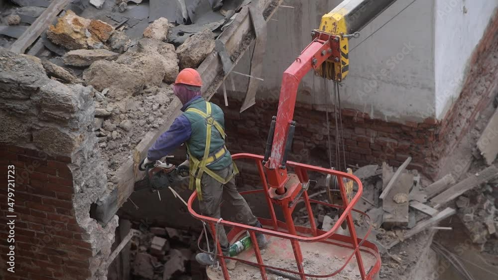 Demolition of old abandoned house, workman in orange helmet at crane ...