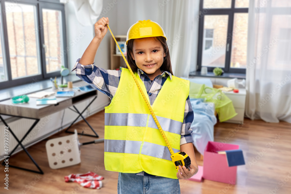 building, construction and profession concept - smiling little girl in ...