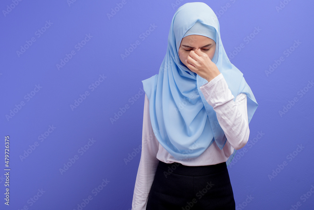 Young muslim woman wearing hijab stressed and tired over blue ...