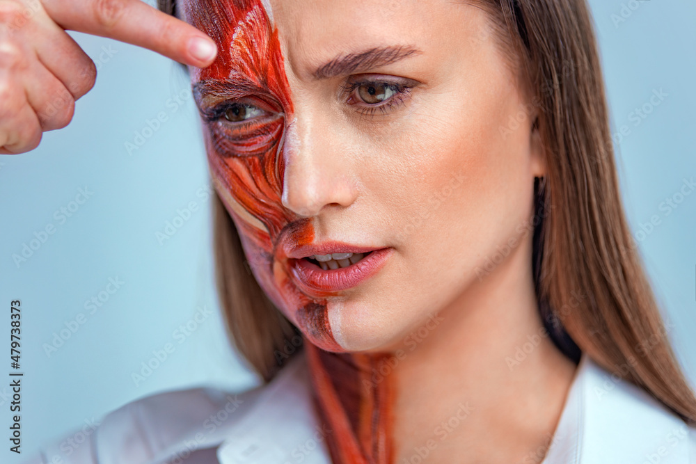 Cosmetology concept. Young woman with half of face with muscles ...
