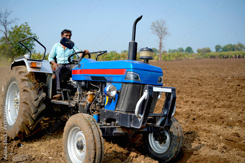 Indian farmer working with tractor in agriculture field. Stock Photo ...