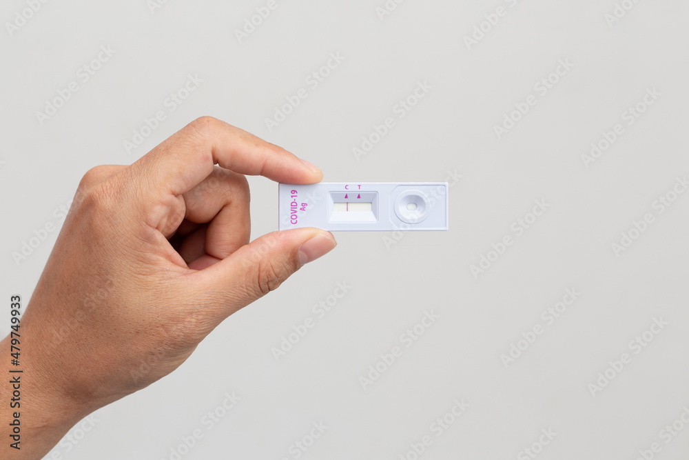 Man holding rapid antigen test kit with the negative result during swab ...