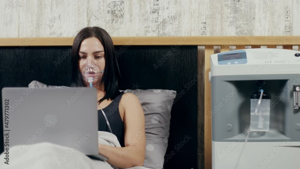 Portrait of a sick young woman who uses an oxygen concentrator and ...