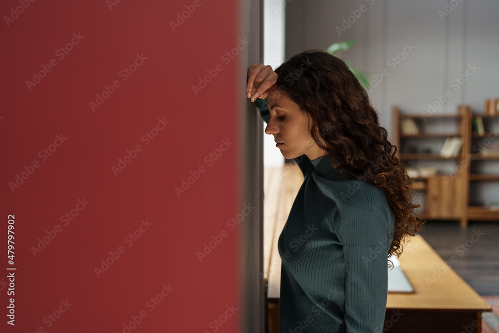 Foto de Job burnout. Young demotivated woman leaning head on wall while ...