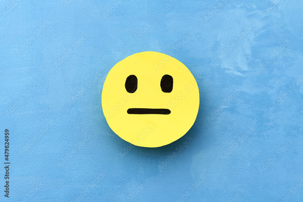 Yellow discreet smiley face on a blue background. The concept of mood ...
