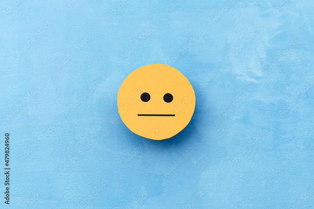 Yellow discreet smiley face on a blue background. The concept of mood ...
