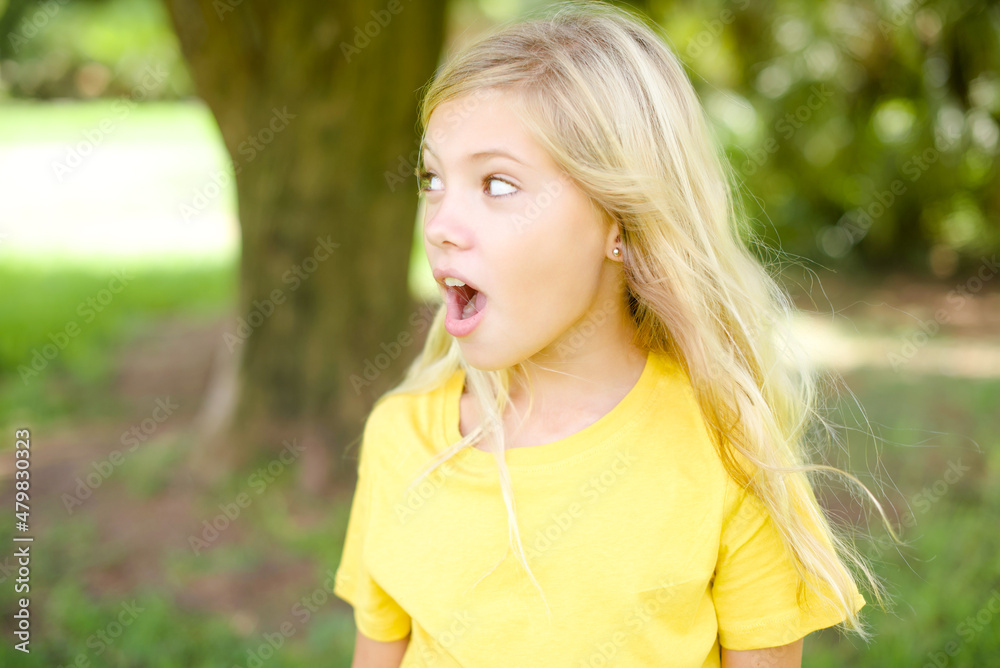 Shocked beautiful Caucasian little kid girl wearing yellow T-shirt ...
