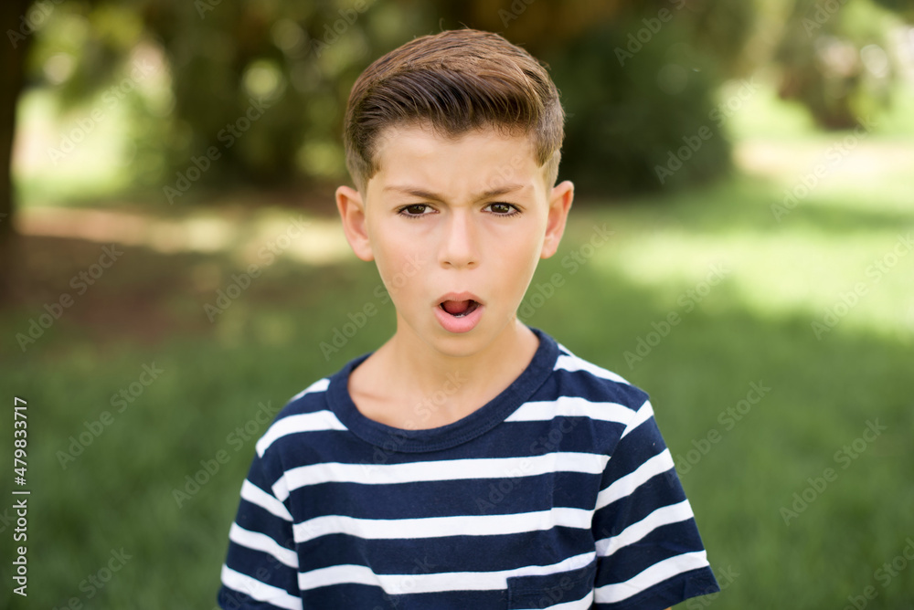 Shocked beautiful Caucasian little kid boy wearing stripped T-shirt ...