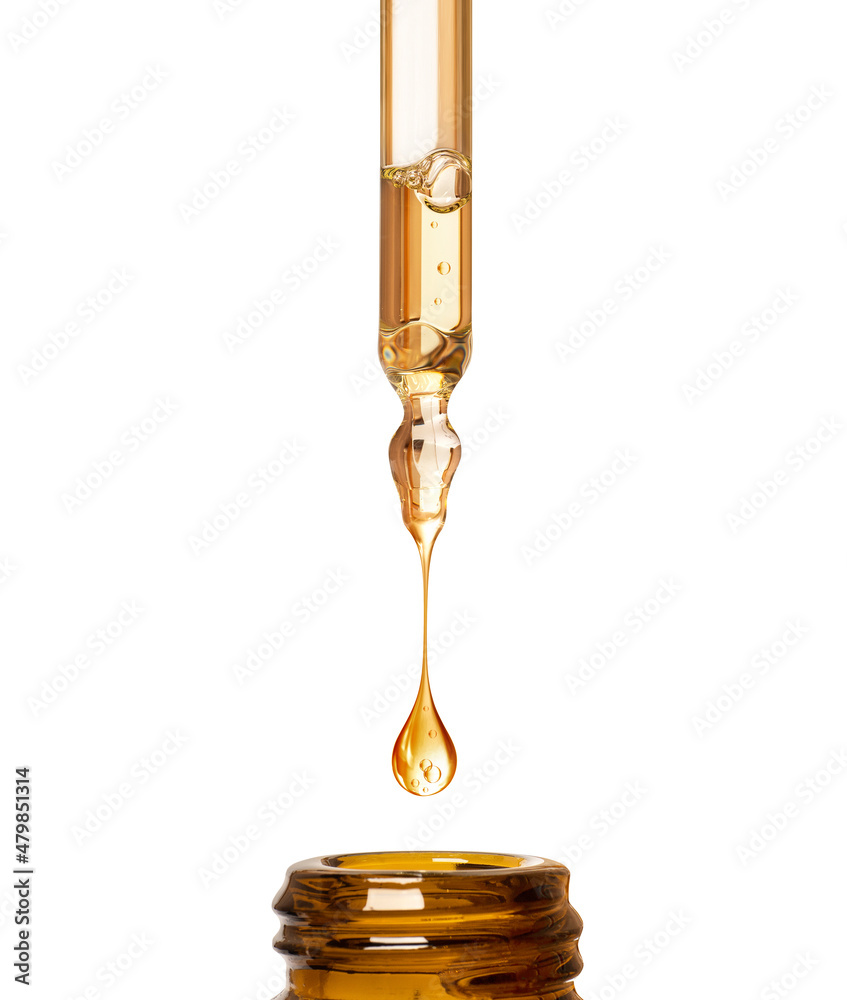 Oily drop dripping from pipette into cosmetic bottle close up, isolated ...