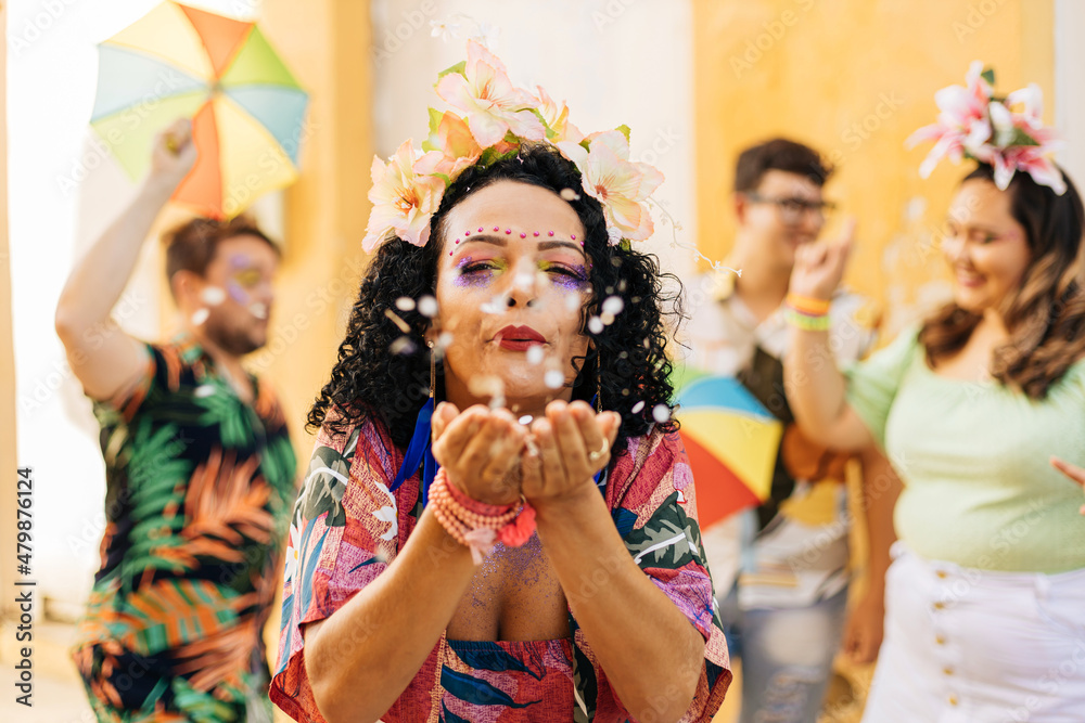 Brazilian Carnival. Young woman enjoying the carnival party blowing ...