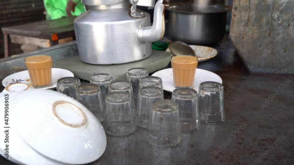 Indian street tea stall with traditional glass cups, saucers and kettle ...