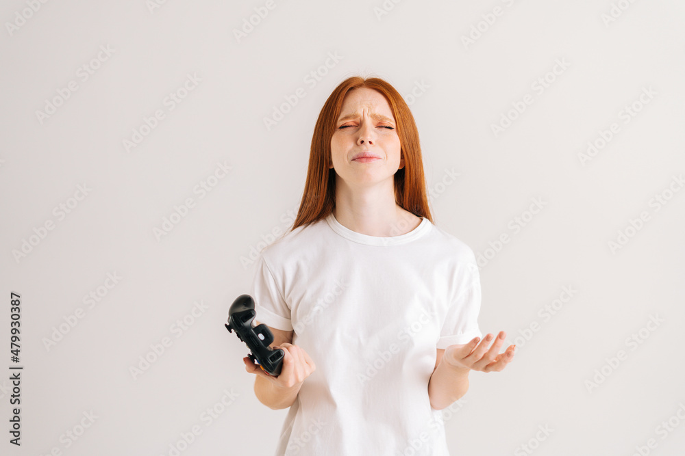 Studio portrait of unhappy crying young woman losing at video games on ...