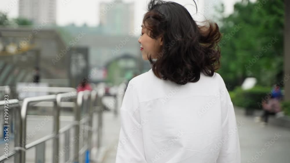 back view Pretty young asian woman walking in the urban street turn ...
