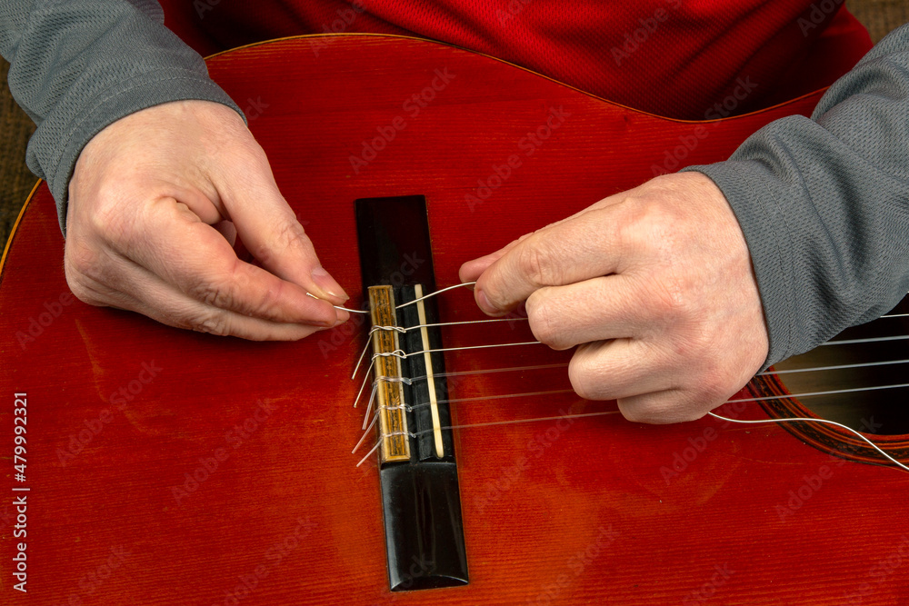 replacement and insertion of nylon strings in a classical guitar ...