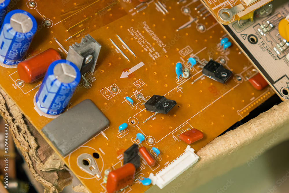 The orange board of a modern TV with transistors and chips. Close-up ...
