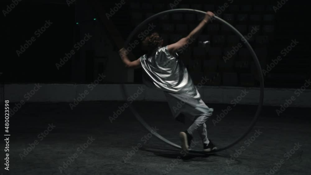Circus artist Rotates on the wheel of Syrah in the arena. A large hoop ...