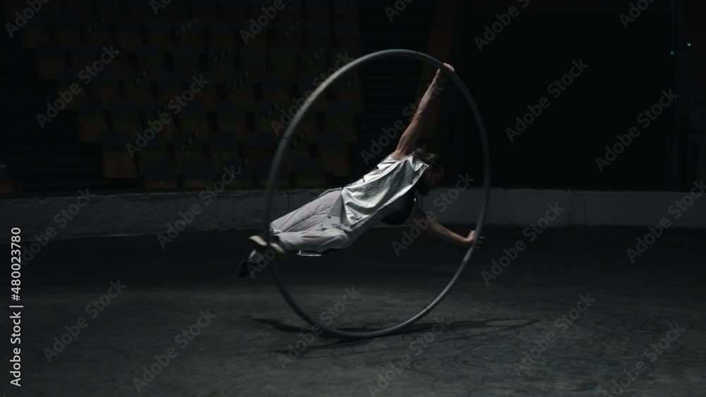 Circus artist Rotates on the wheel of Syrah in the arena. A large hoop ...