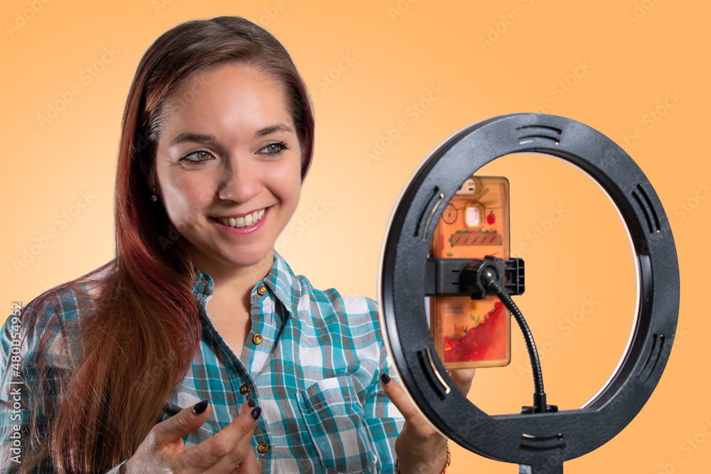 Mujer streamer transmitiendo en vivo desde su celular, usando luz led ...